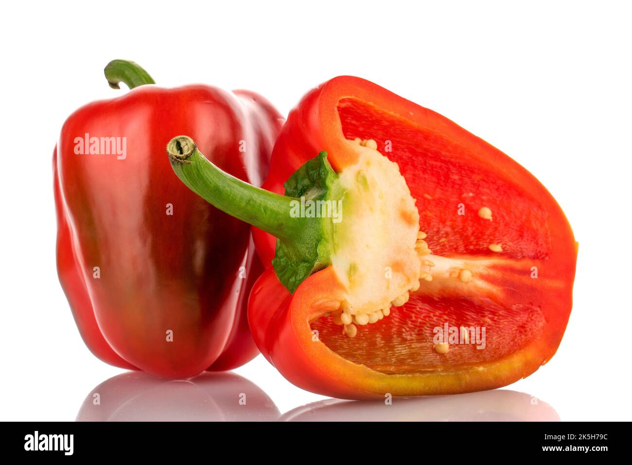 One whole and one half of a red bell pepper, close-up, isolated on ...