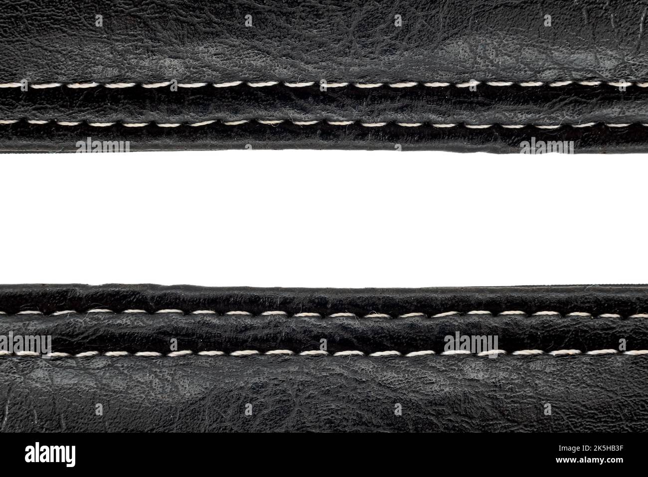 A piece of leather stitched with threads on a white background with ...