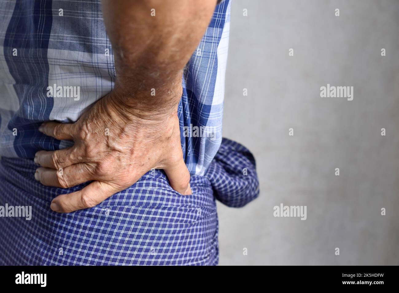 Asian elder man suffering from right sided low back and loin pain. It ...