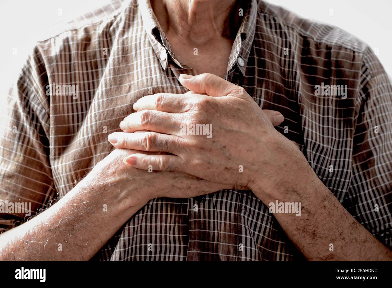 Asian elder man suffering from central chest pain. Chest pain can be ...