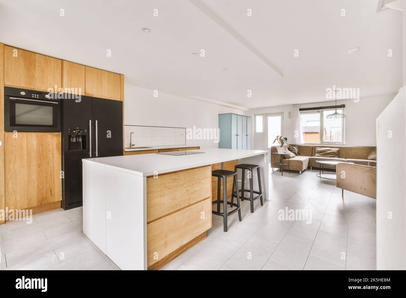 Contemporary open plan kitchen with dining table set and gray sofa in ...