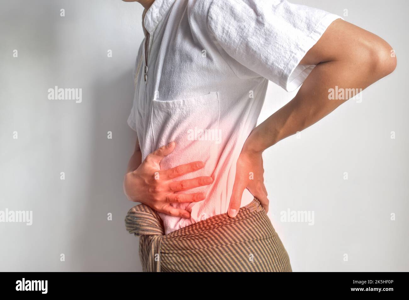 Asian young man suffering from back and loin pain. It can be caused by ...