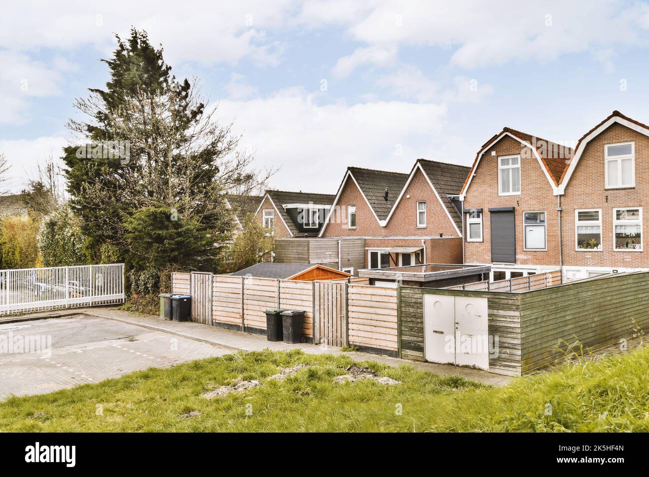 The front view of a brick building with signs, pavement and wooden ...