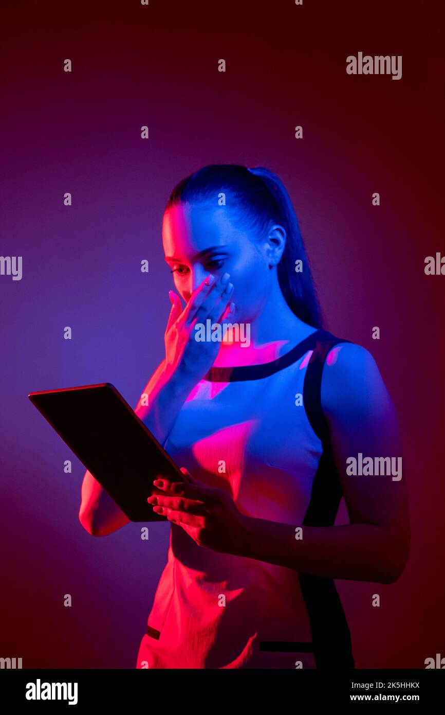 cyber attack digital scam scared neon woman tablet Stock Photo - Alamy