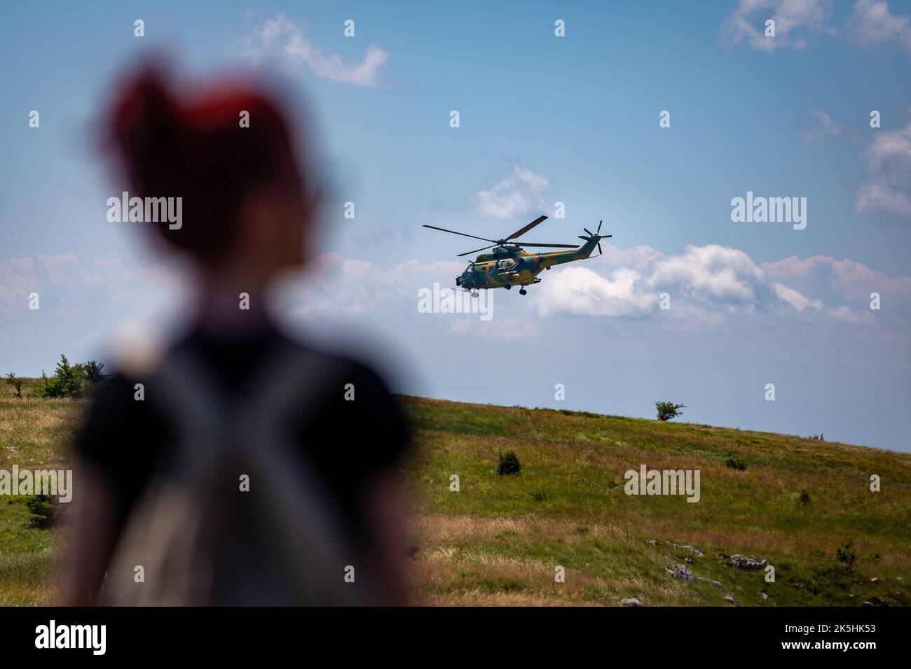 A blur girl looking at IAR 330 Aircraft model helicopter flying in the ...