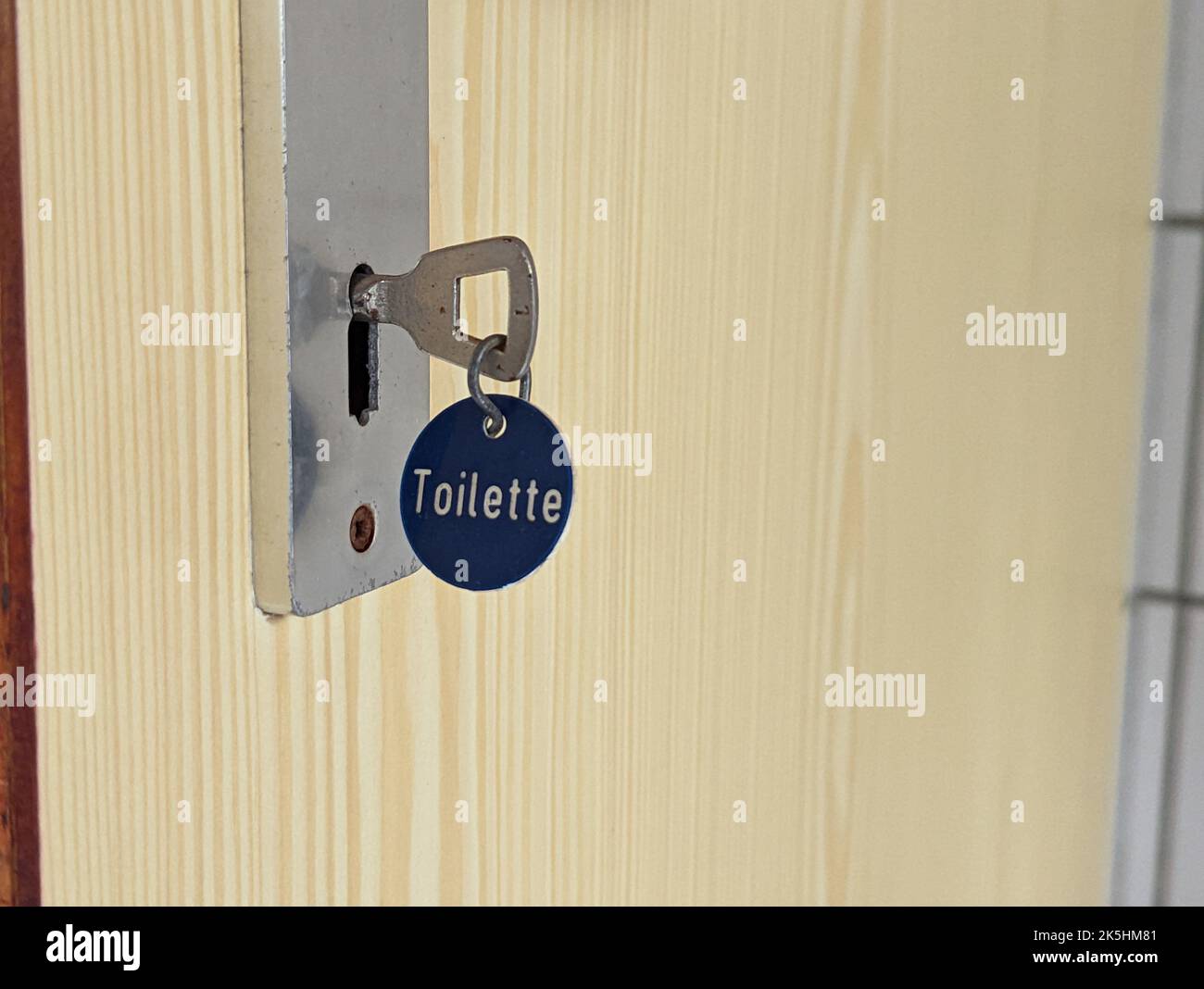 An old-fashioned door lock with a key, a round blue key plate with the ...