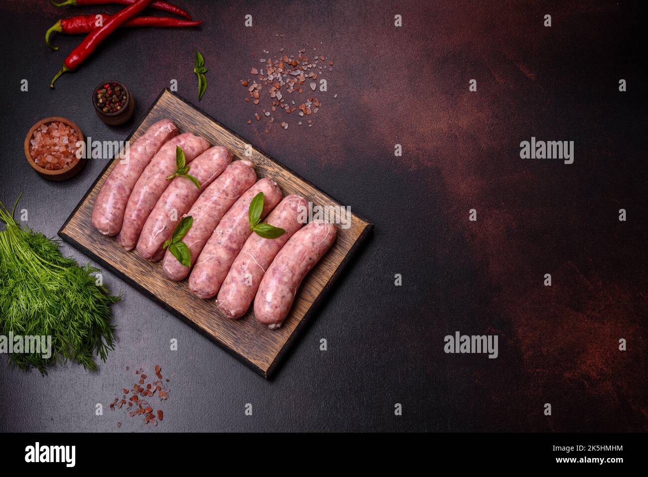 Raw barbecue sausages with spices and herbs. Free space for your text ...
