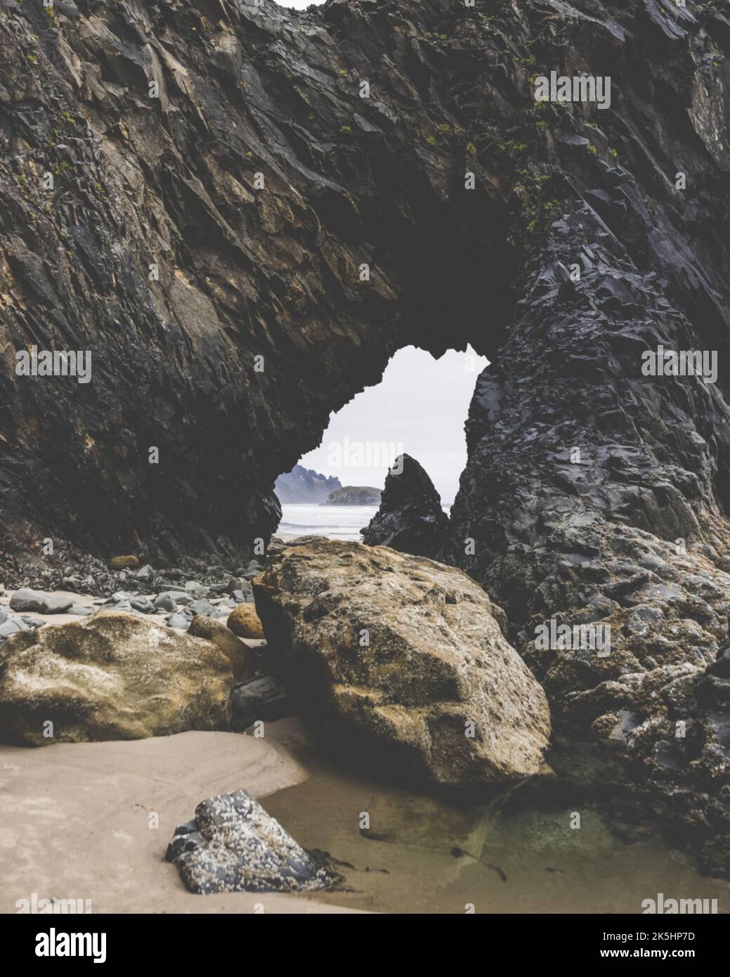 A vertical shot of a huge rock with a hole Stock Photo - Alamy