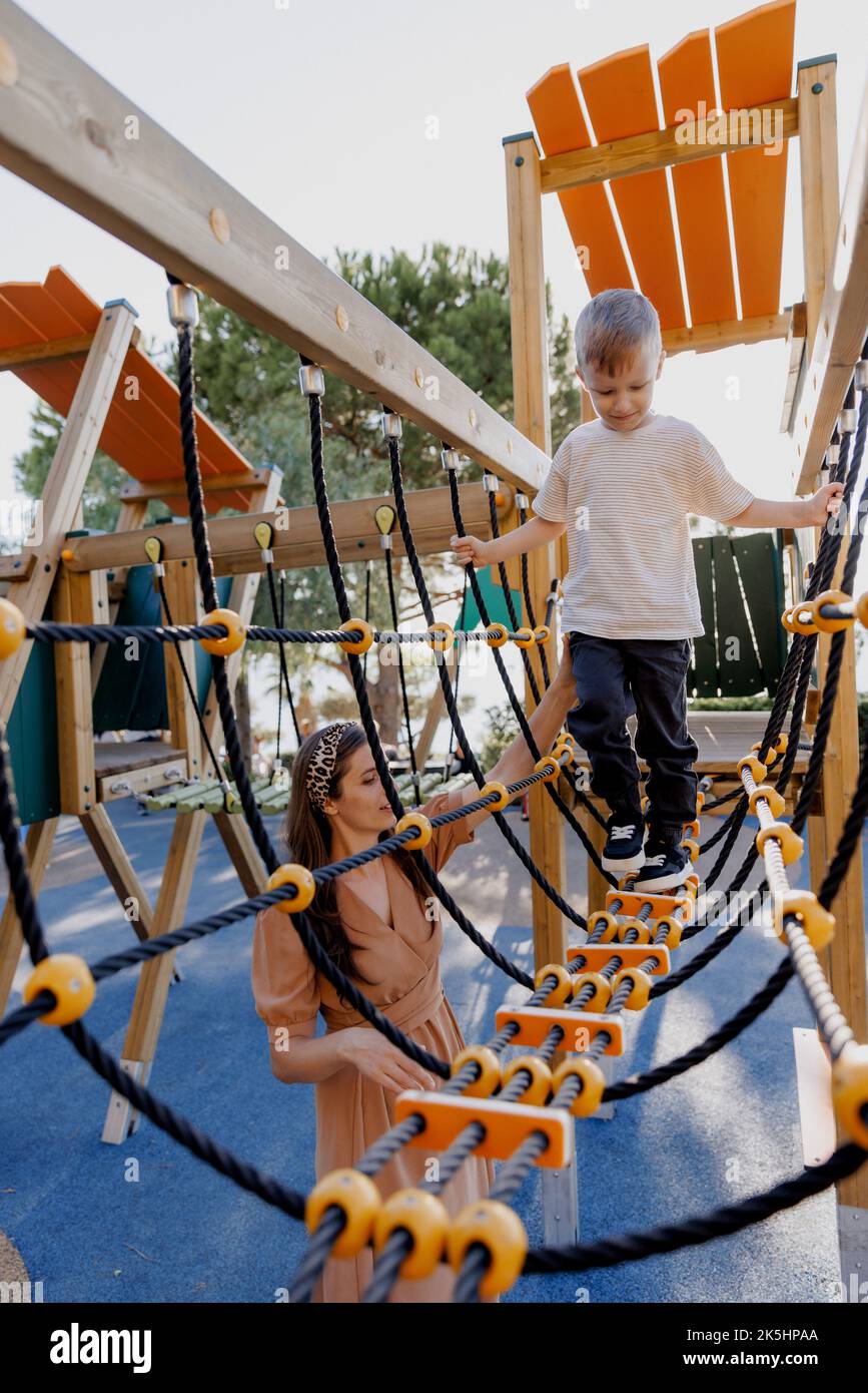 A vertical shot of a caucasian little boy playing on the playground ...