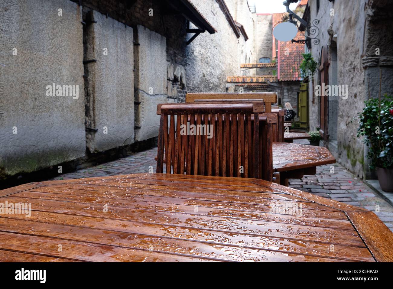 Catherine Lane in Tallinn, Estonia, on a rainy day. Wet tables and ...
