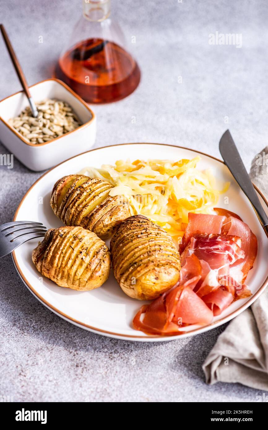 Close-Up of a plate of Hasselback potatoes with fermented cabbage salad ...