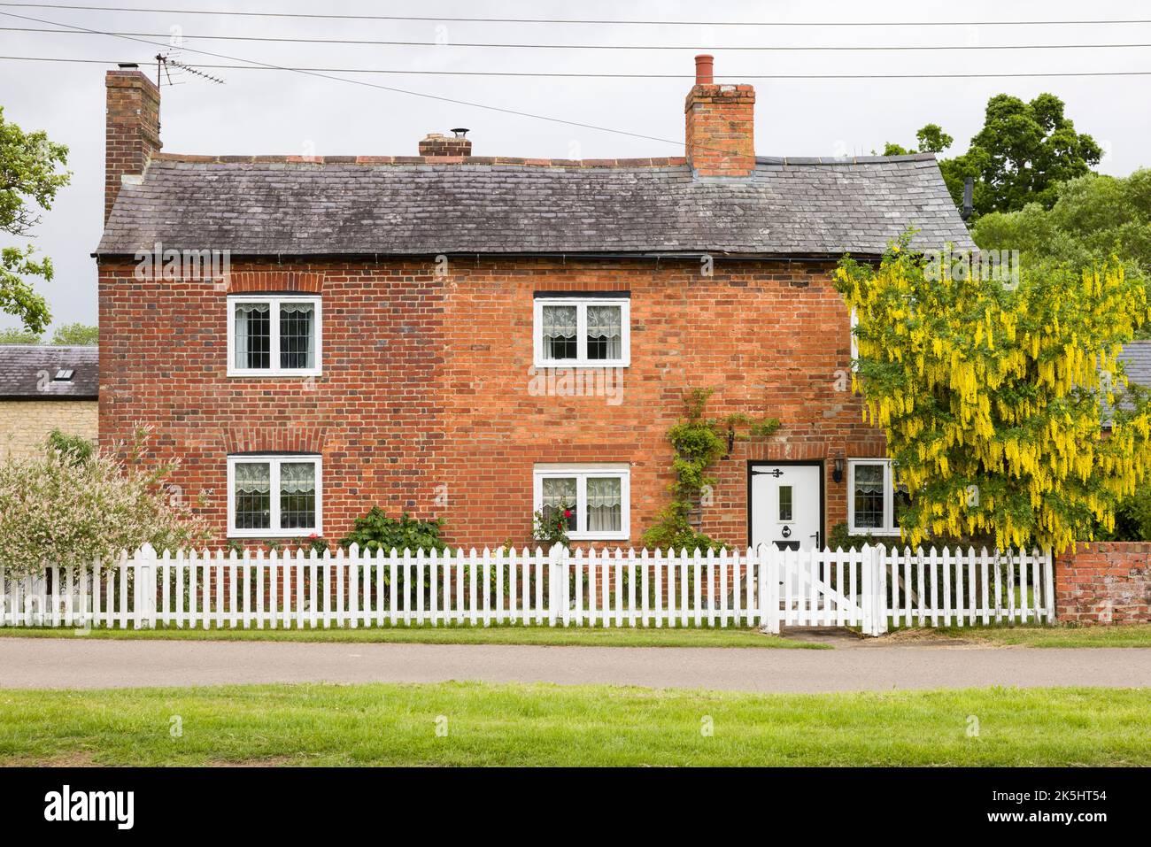 Brick house picket fence hi-res stock photography and images - Alamy