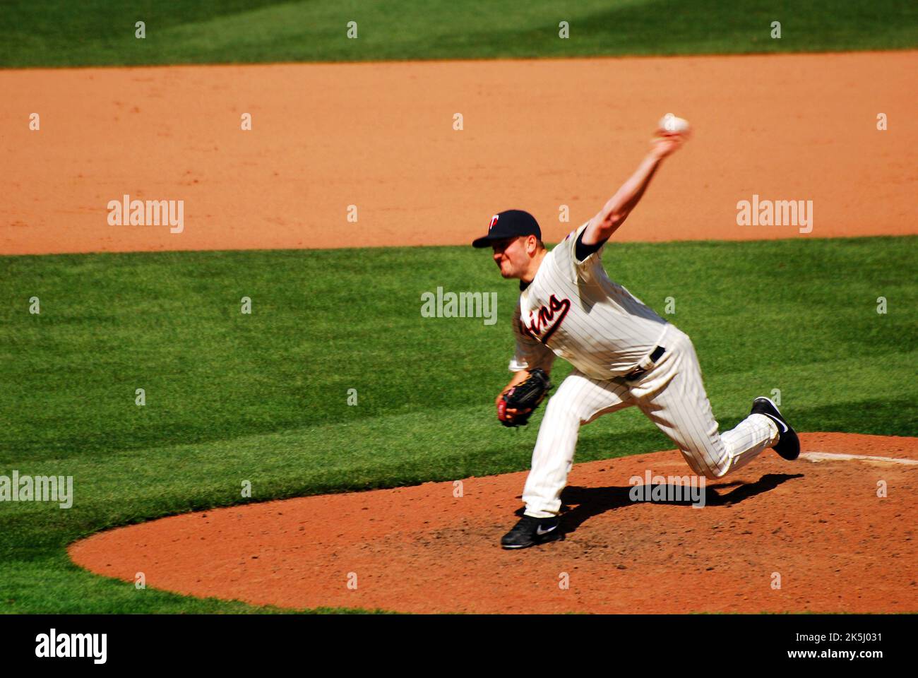 A Minnesota Twins Pitcher reaches back to throw a fastball at a ...