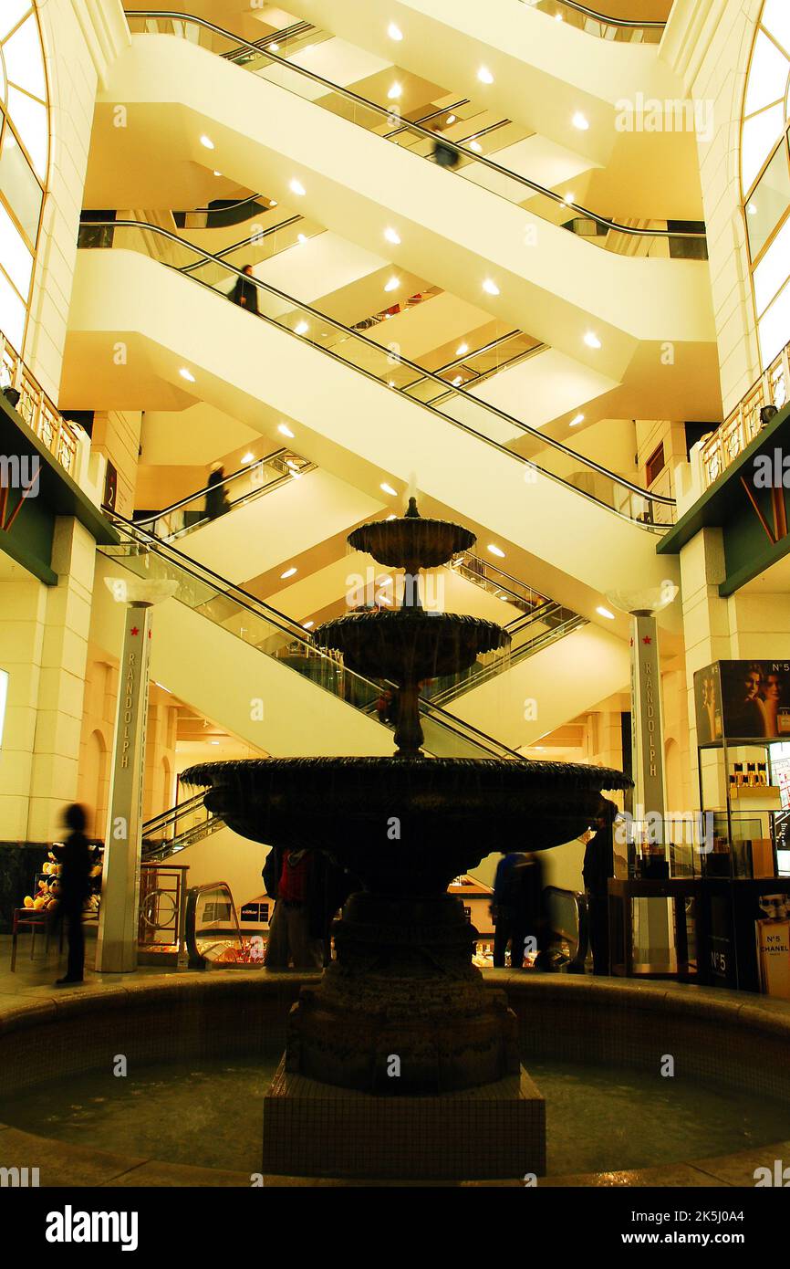 Escalators create diagonal lines over a water fountain in the newer ...
