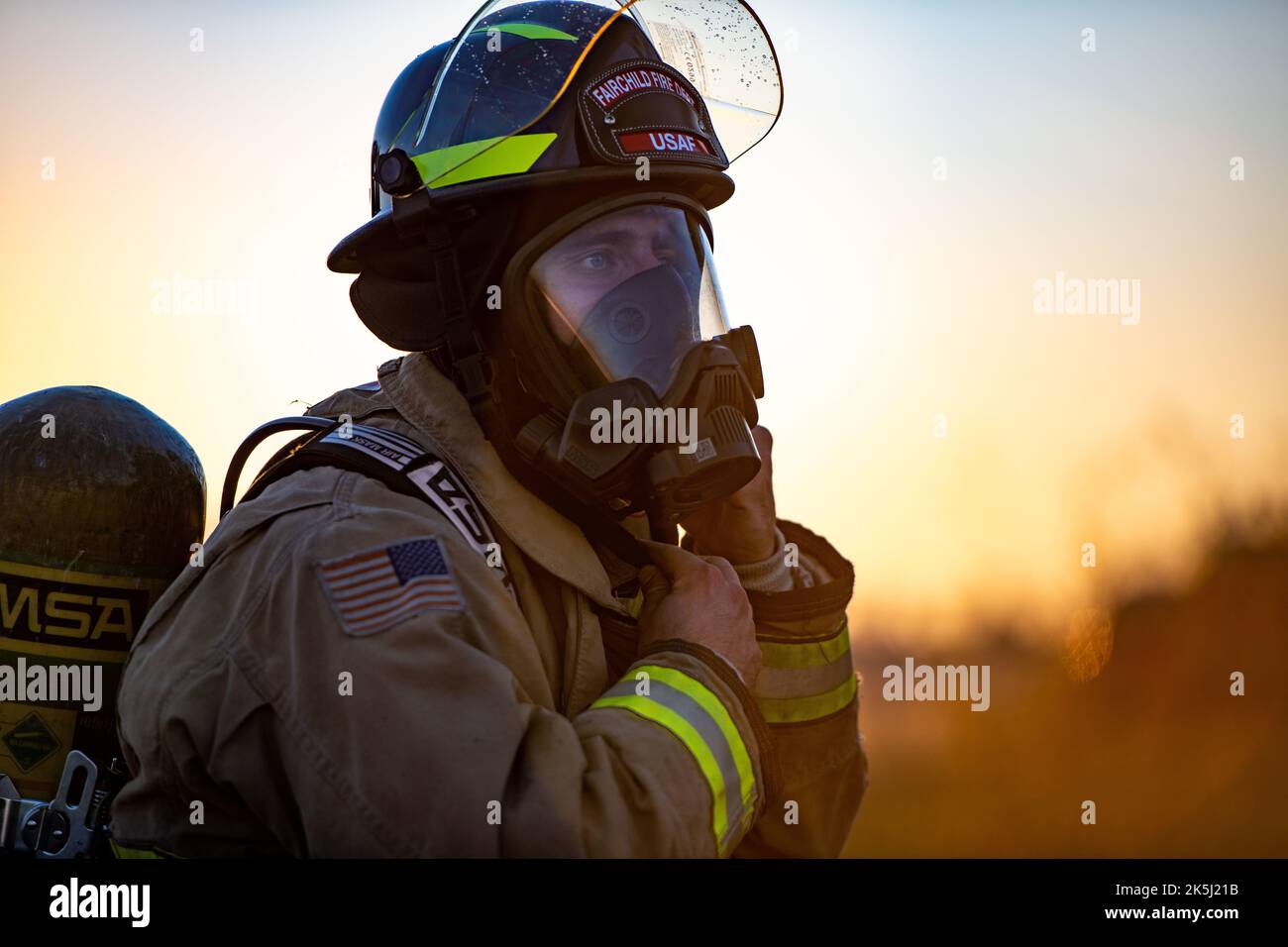 A firefighter from the 92nd Civil Engineer Squadron adjusts his oxygen ...