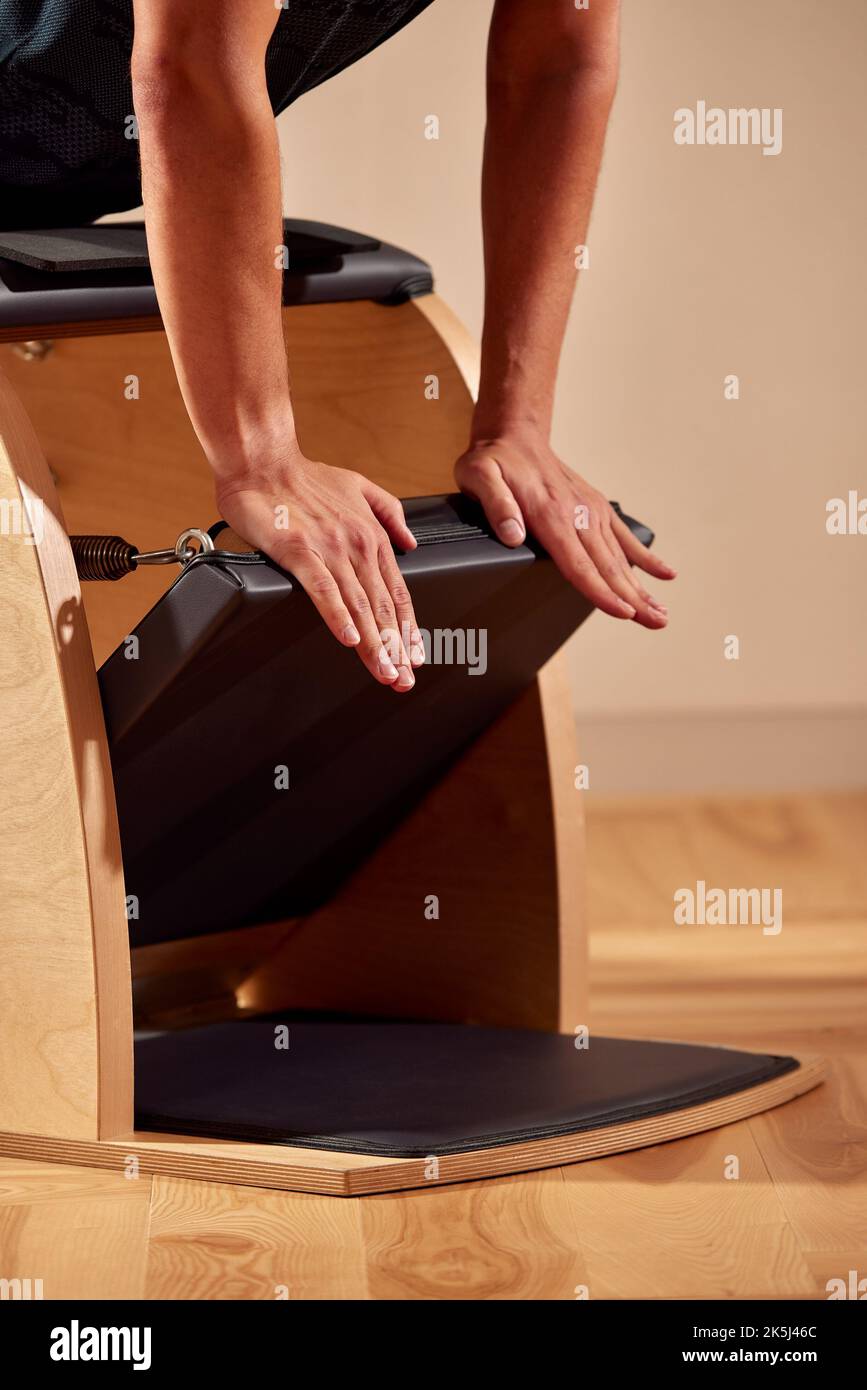 Handsome pilates male instructor performing stretching balance fitness ...