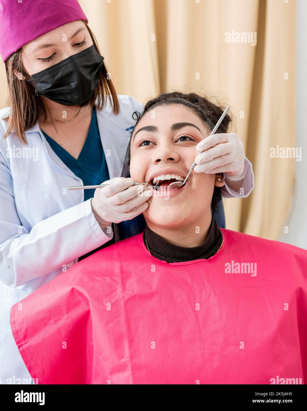 Dentist checking patient with excavator and dental mirror, Front view ... Dentist checking patient with excavator and dental mirror, Front view ...