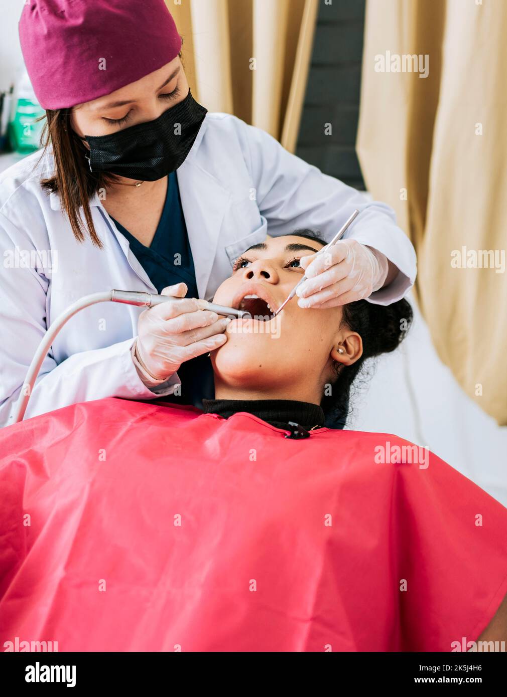 Professional dentist cleaning a female patient's mouth, Female dentist ...
