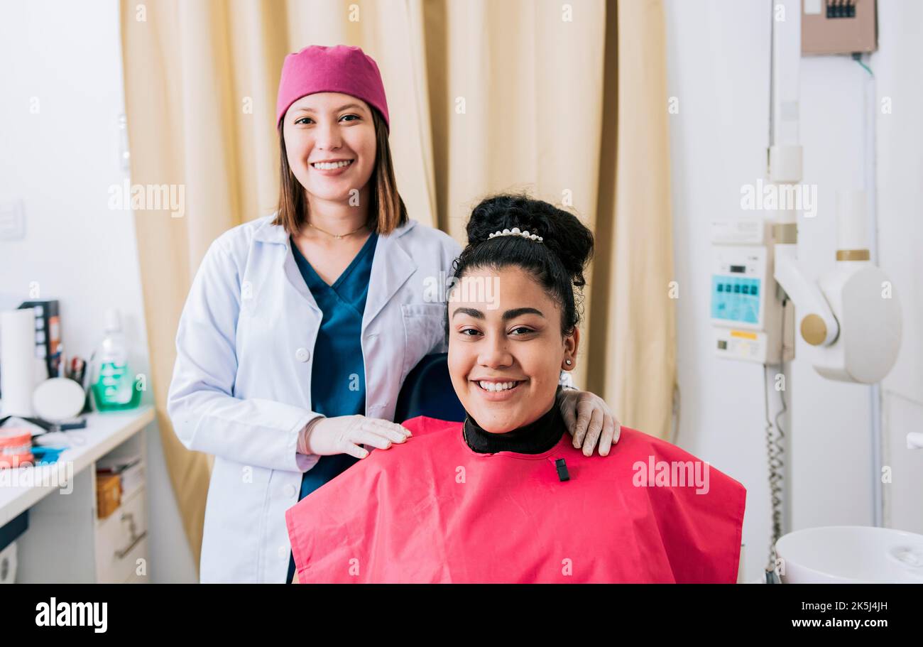 Female dentist with satisfied patient smiling at camera, Female dentist ...