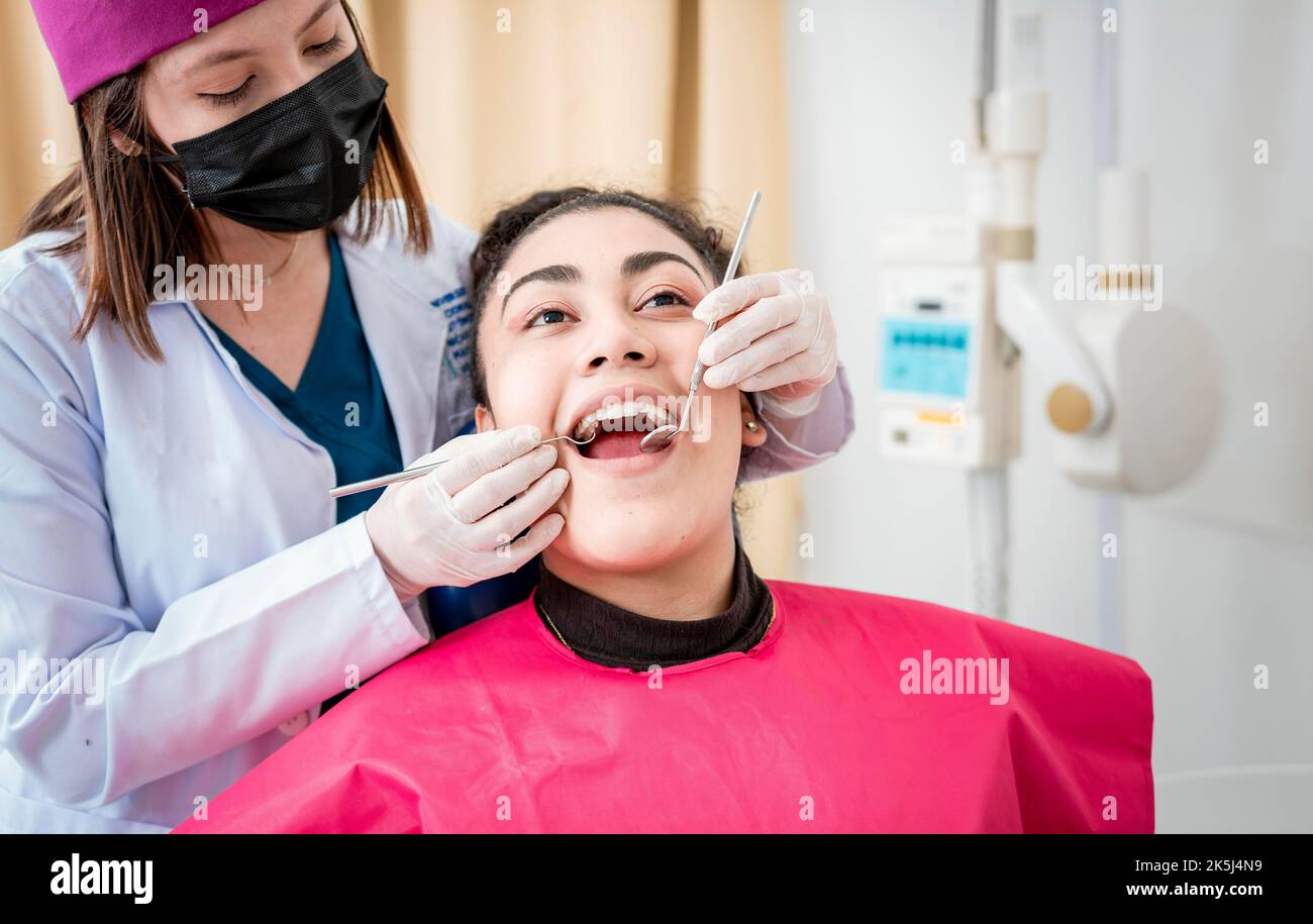 Front view of dentist checking patient with excavator and dental mirror ... Front view of dentist checking patient with excavator and dental mirror ...