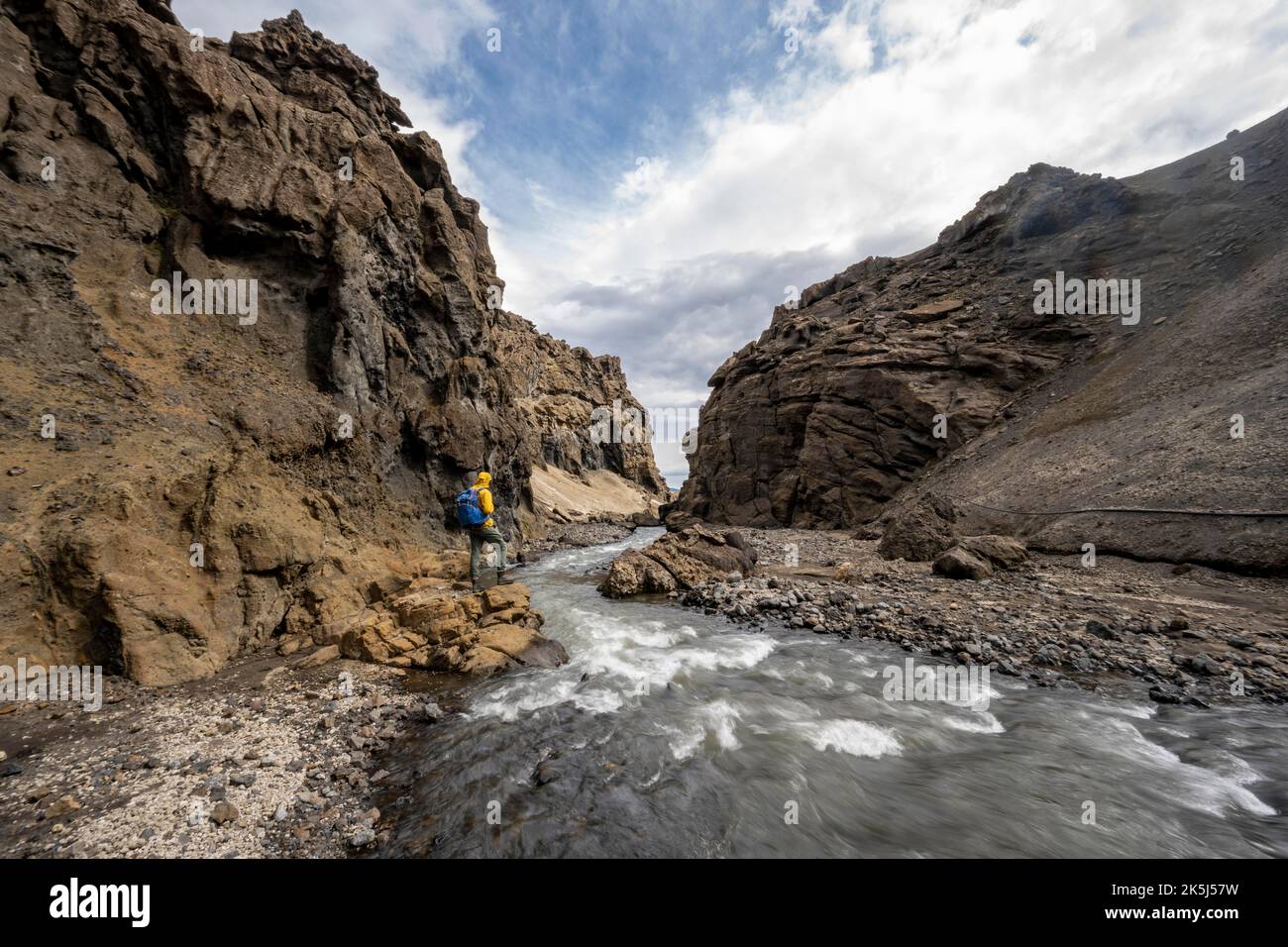 Hikers by the river, Drekagil, gorge in the crater rim of Askja volcano ...