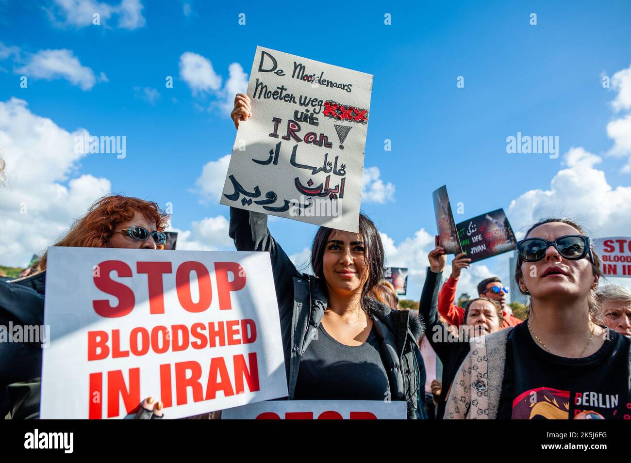 A woman is seen holding a placard that says 'The killers must leave ...