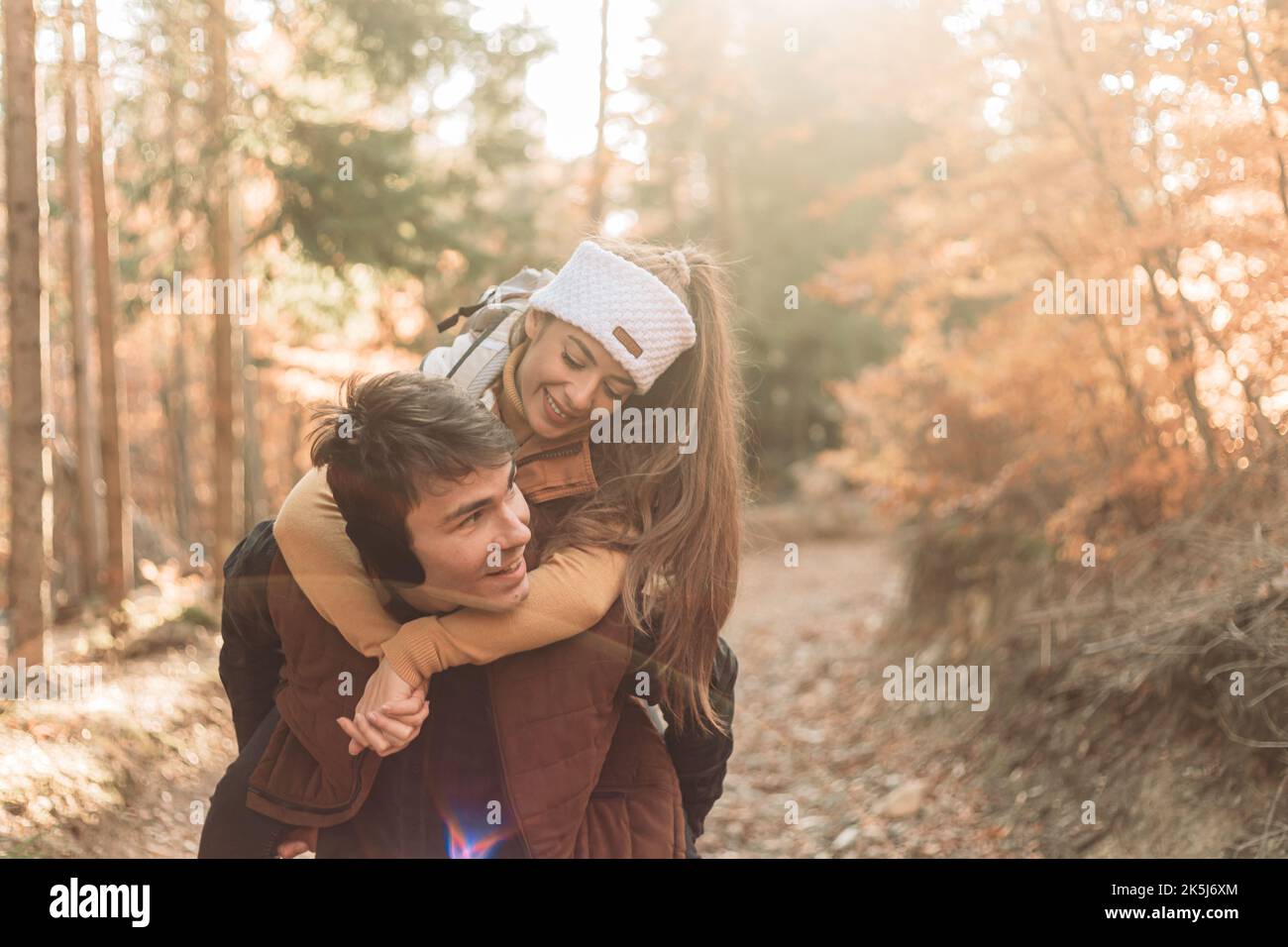 Young romantic couple in the woods. Piggyback riding. Happy together ...