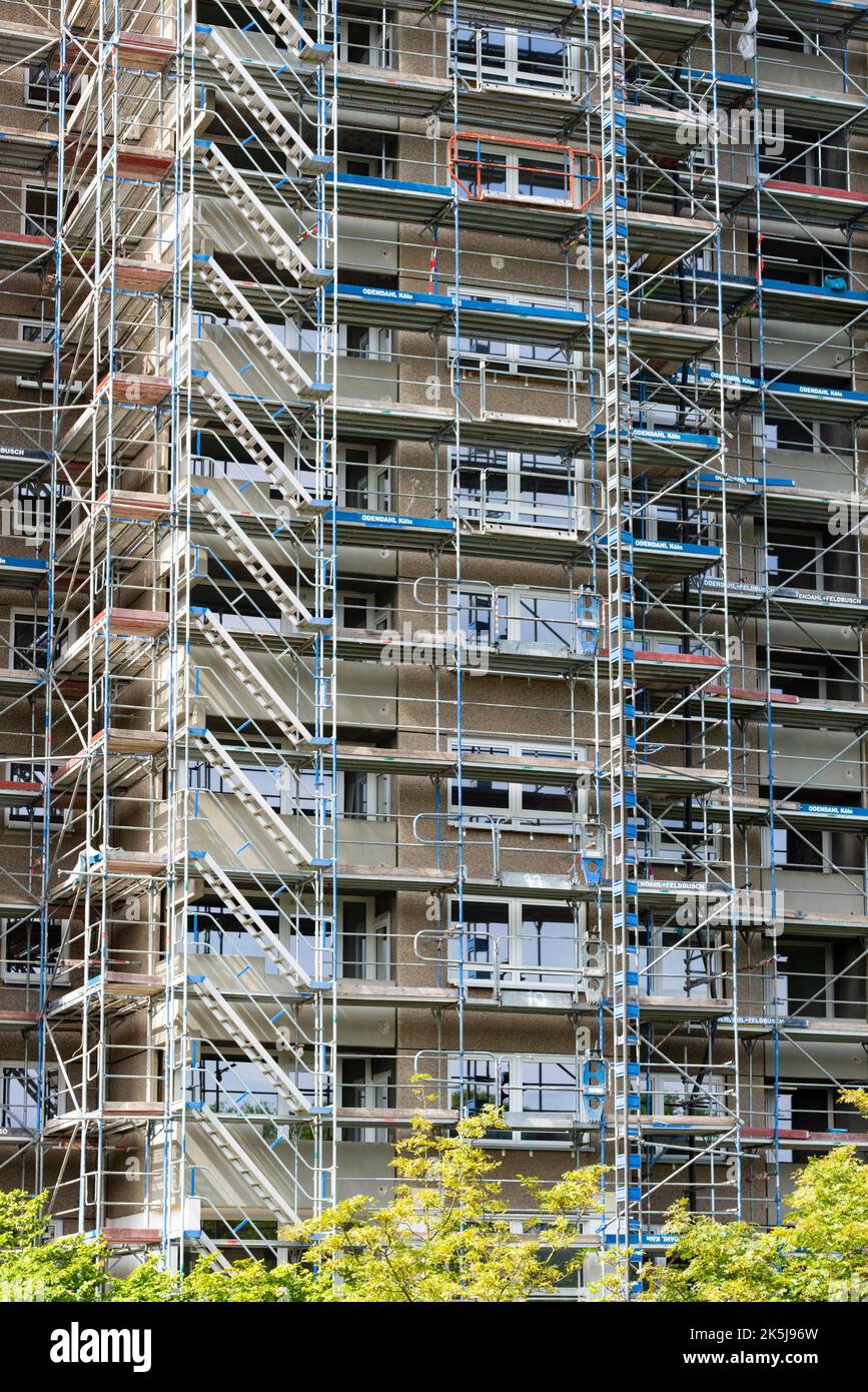 Scaffolded high-rise residential building with balconies and satellite ...