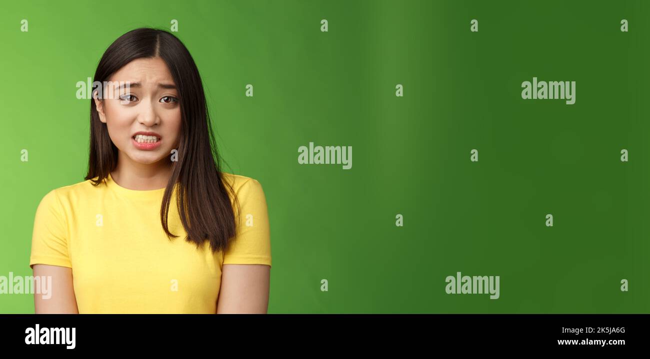 Anxious worried cute asian girl brunette clench teeth frowning shaking ...