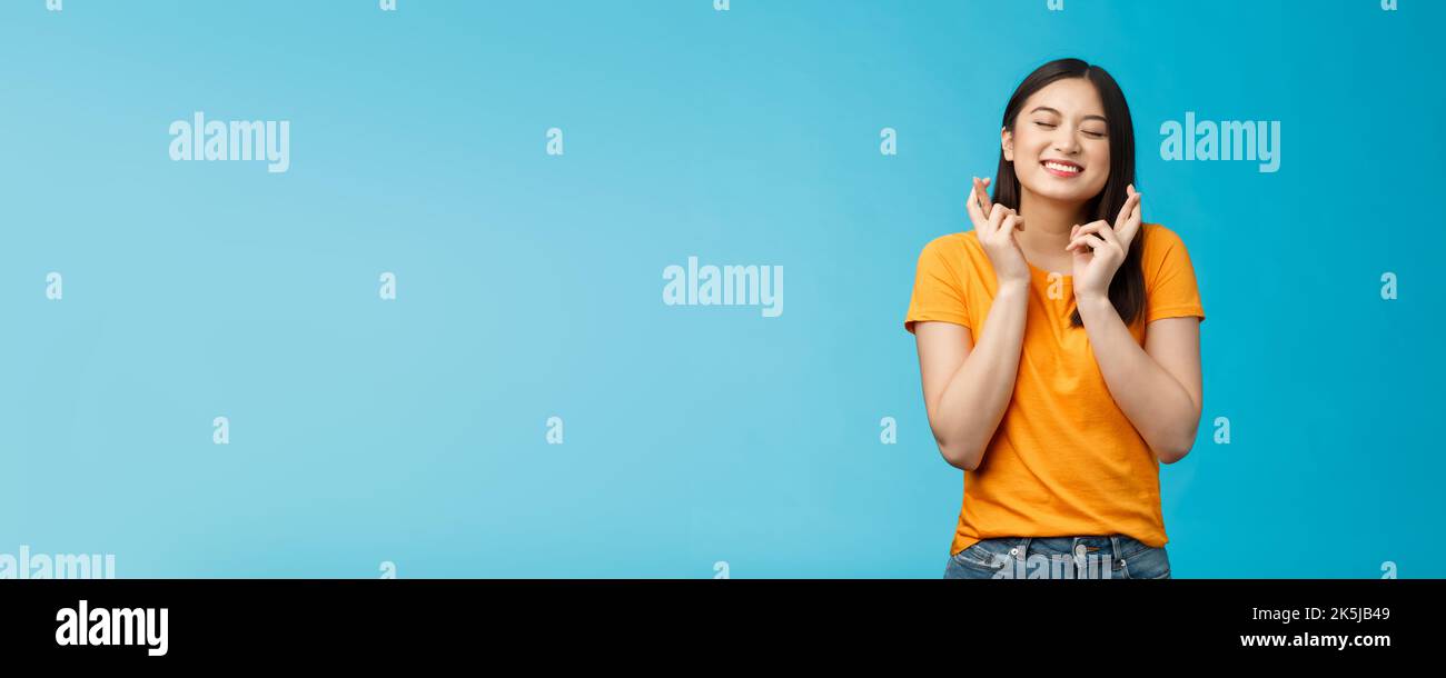 Hopeful excited asian young girl making wish cross fingers good luck ...