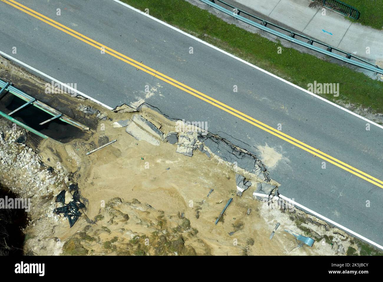 Aerial view of damaged road after flood water washed away asphalt ...