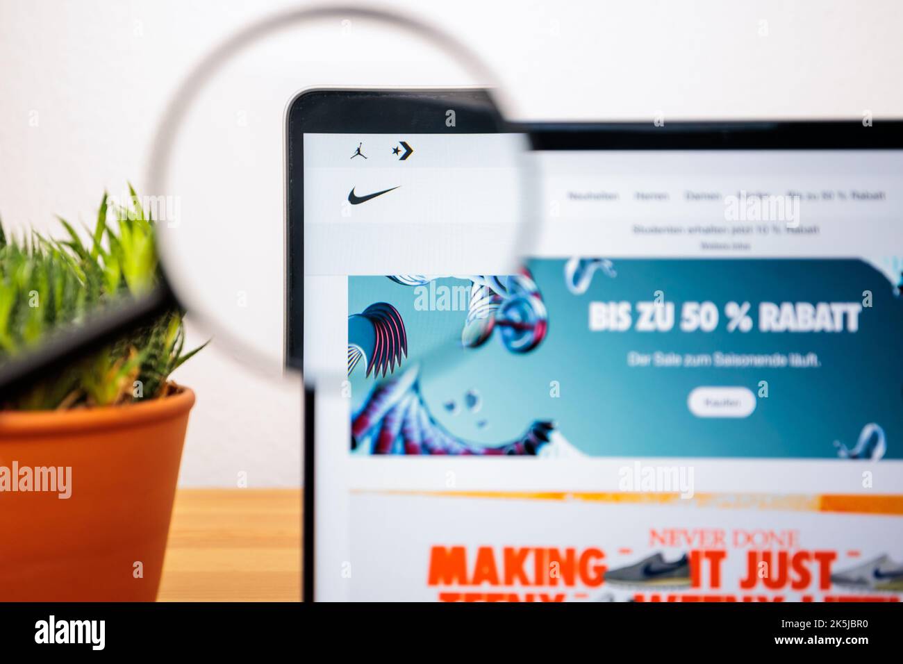The logo of Nike on a laptop desktop under a magnifying glass Stock ...
