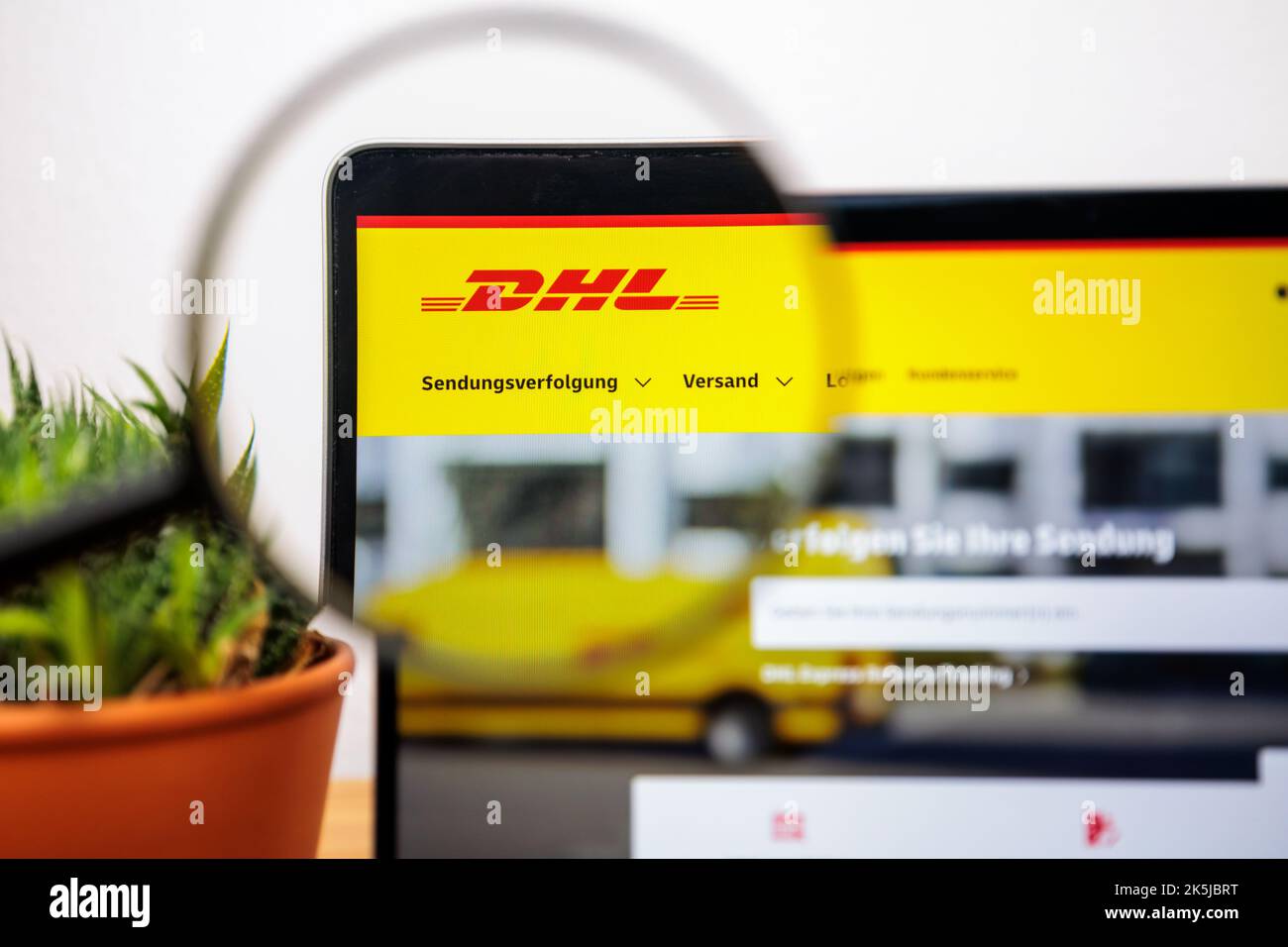 The logo of DHL on a laptop desktop under a magnifying glass Stock ...