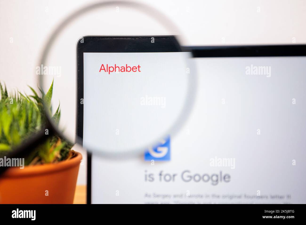 The logo of Alphabet on a laptop desktop under a magnifying glass Stock ...
