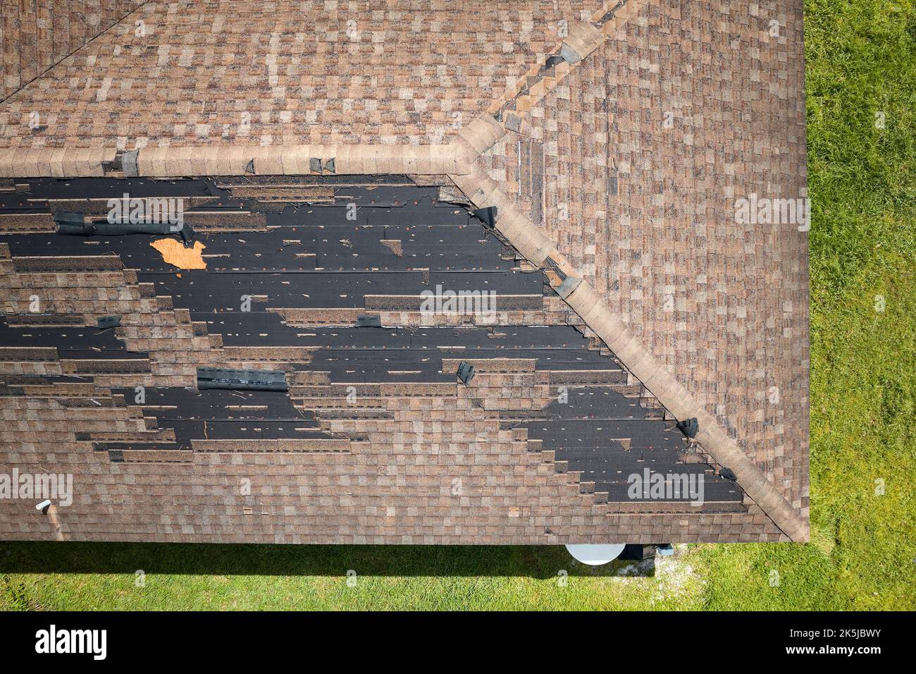 Damaged house roof with missing shingles after hurricane Ian in Florida ...
