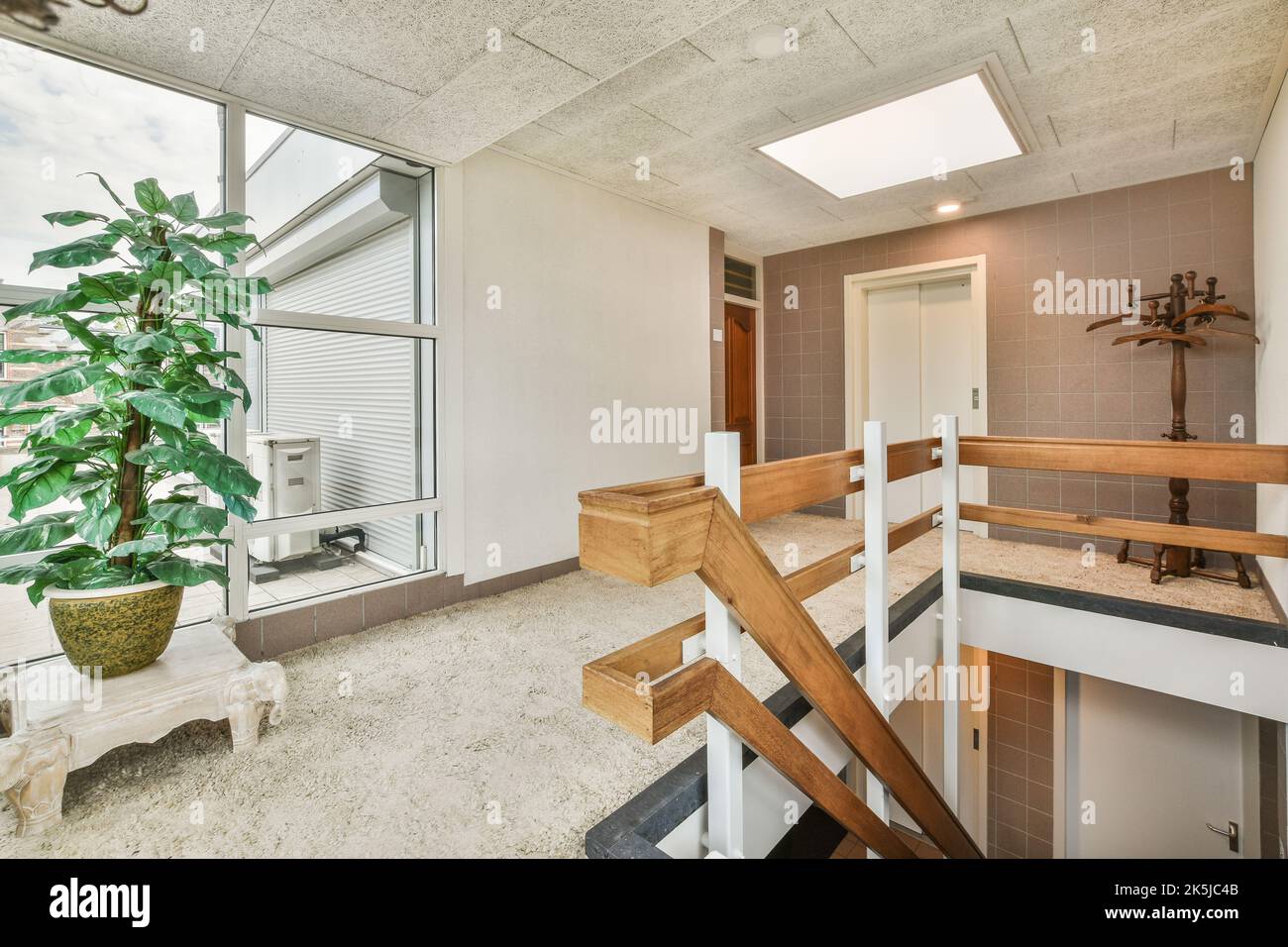 Light hallway with entrance door in two level apartment with minimalist ...