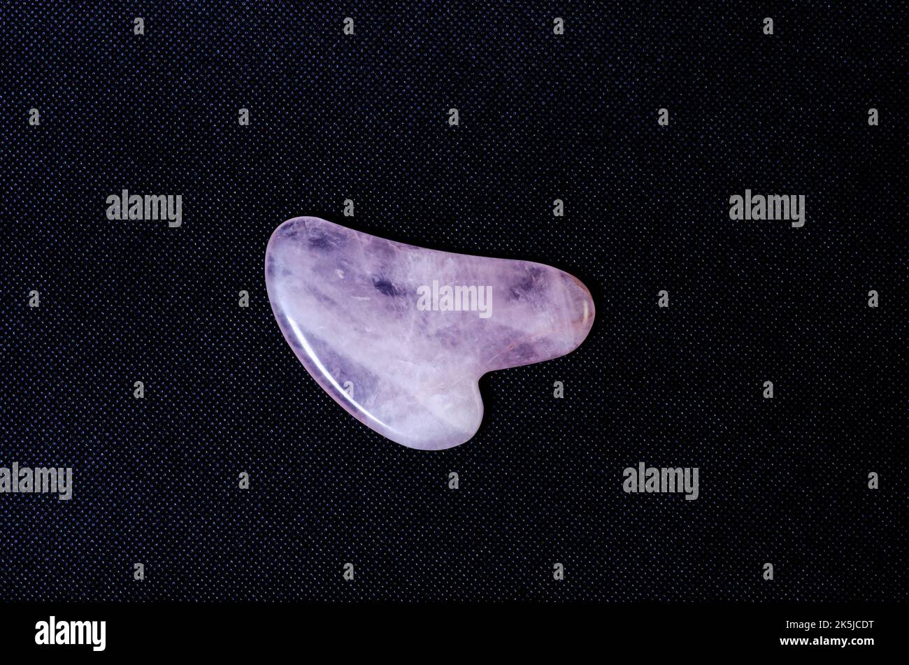 rose quartz facial roller and massage stone gua sha isolated on white ...