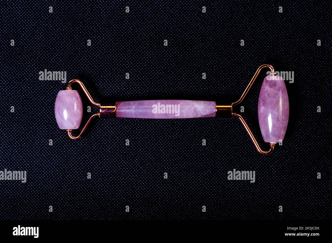 rose quartz facial roller and massage stone gua sha isolated on white ...