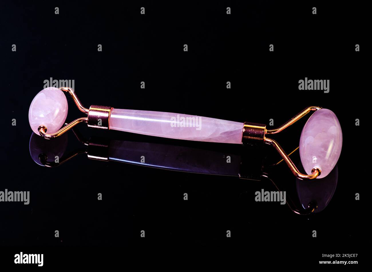 rose quartz facial roller and massage stone gua sha isolated on white ...