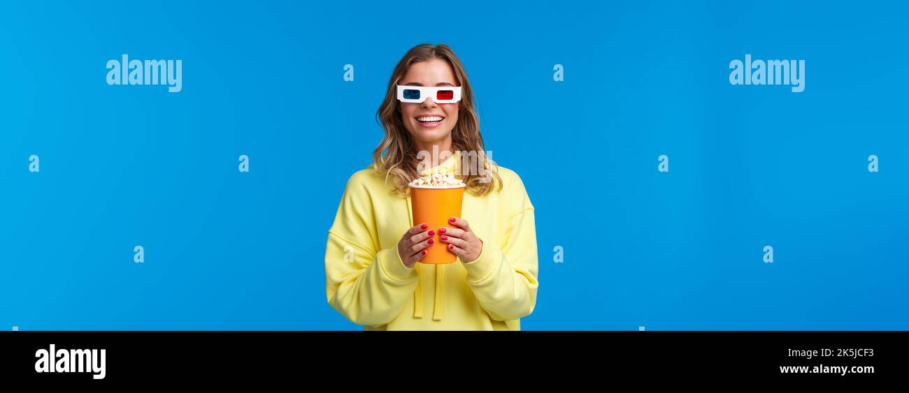 Lets watch movie. Excited cute young blond girl in 3d glasses, holding ...