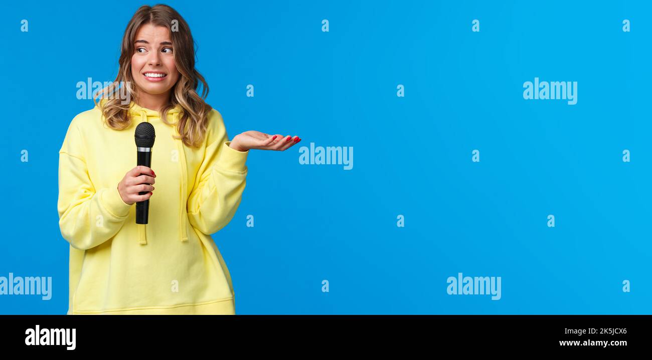 Awkward cute blond girl dont know lyrics as singing karaoke, looking at ...