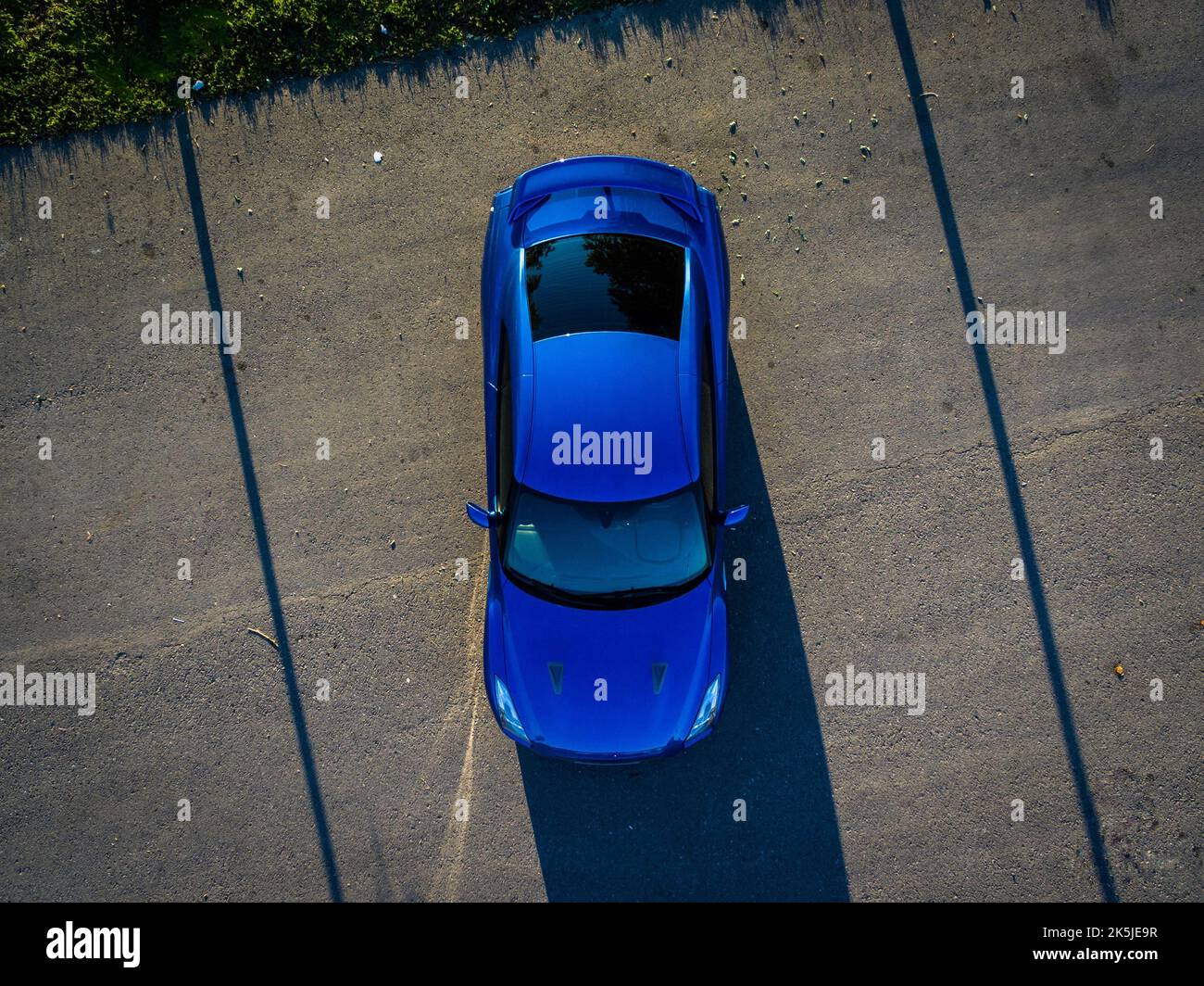 A high-angle top view of an electric blue car parked in a location ...