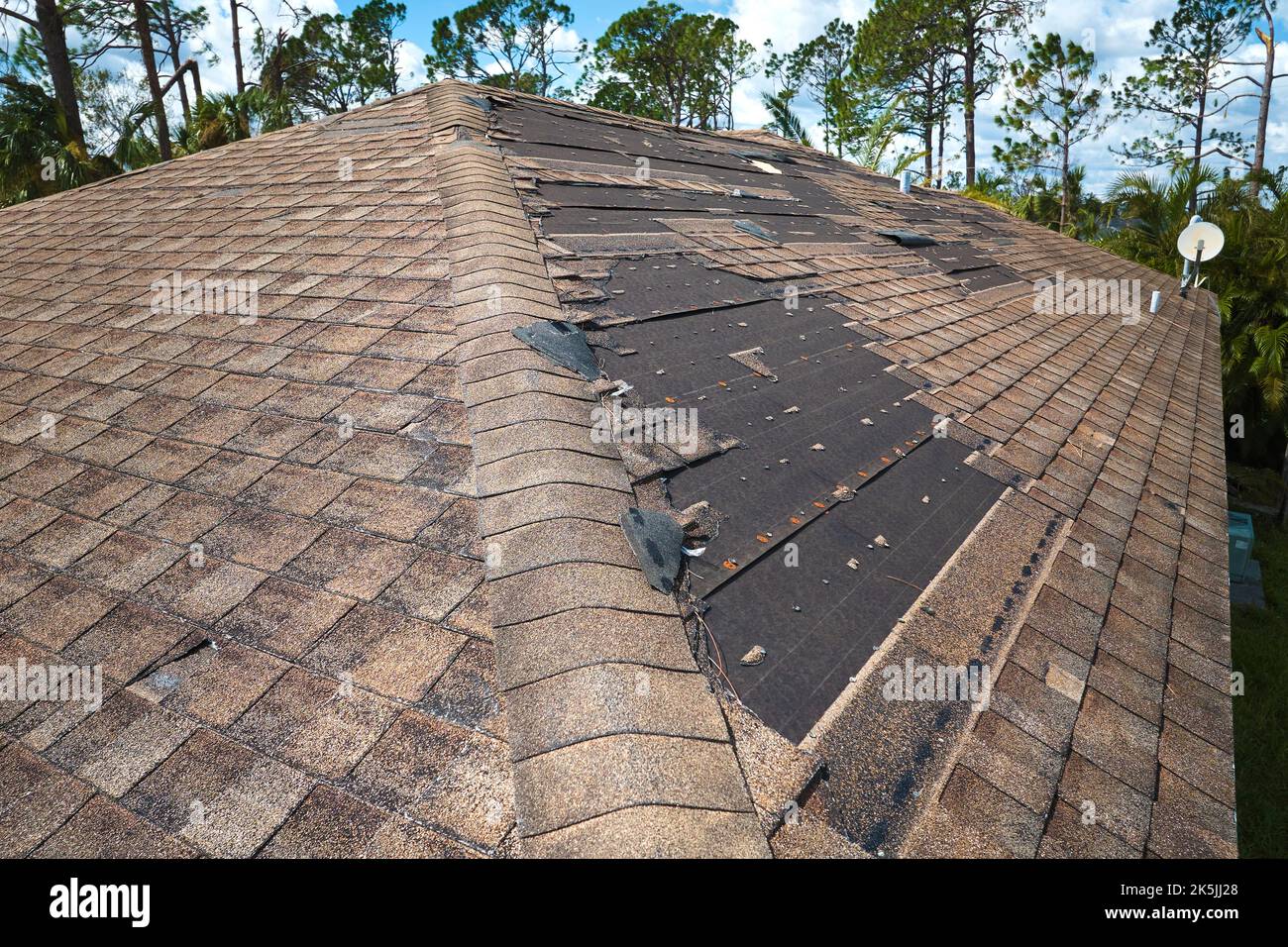 Damaged house roof with missing shingles after hurricane Ian in Florida ...
