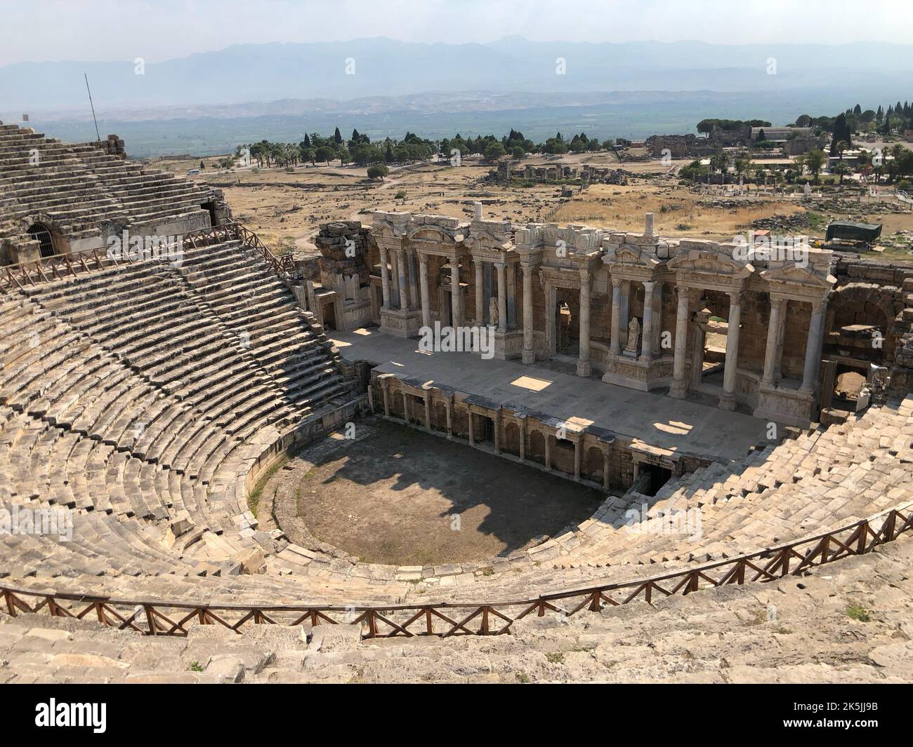 An ancient Roman arena with sculptures and columns in the countryside ...