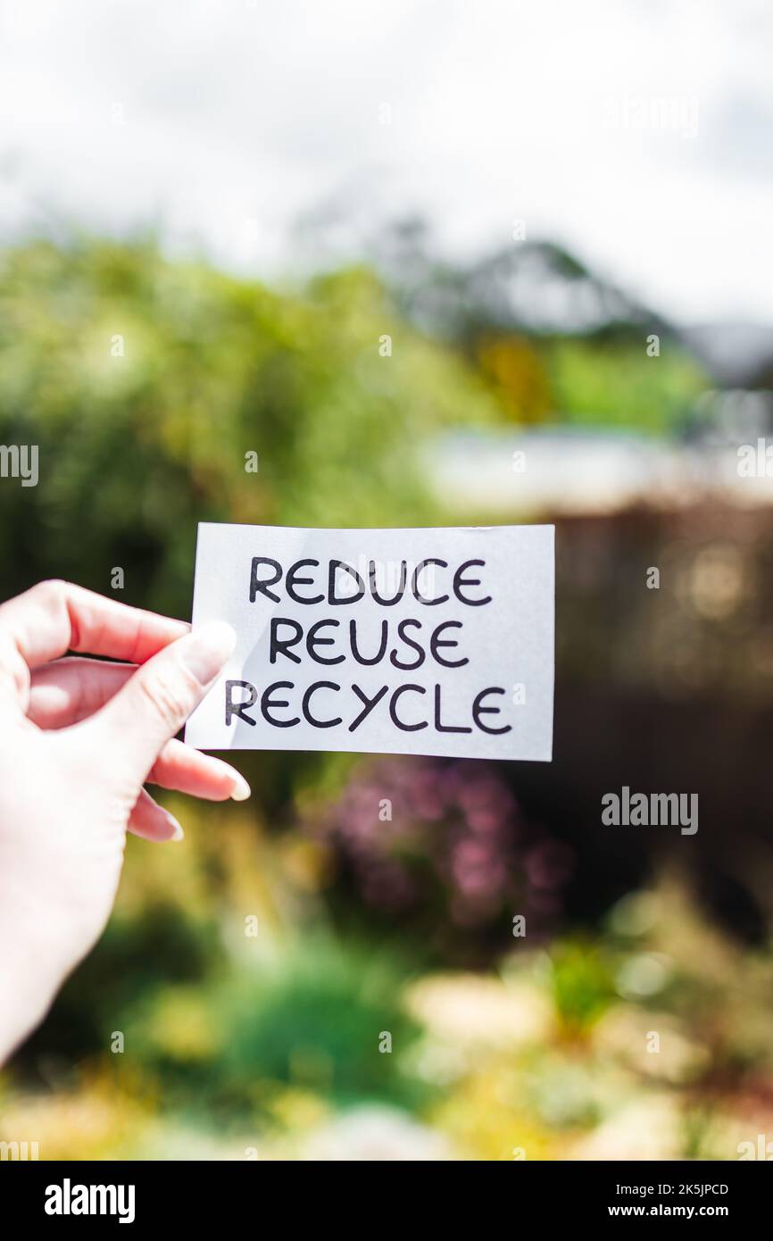 reduce reuse recycle sign in front of backyard bokeh, concept of ...