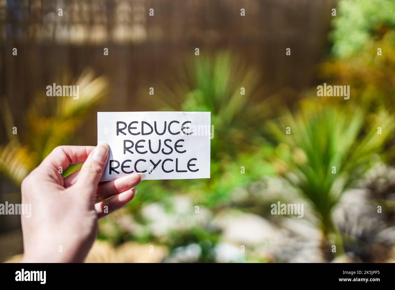 reduce reuse recycle sign in front of backyard bokeh, concept of ...