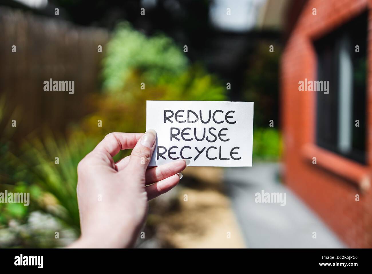 reduce reuse recycle sign in front of backyard bokeh, concept of ...