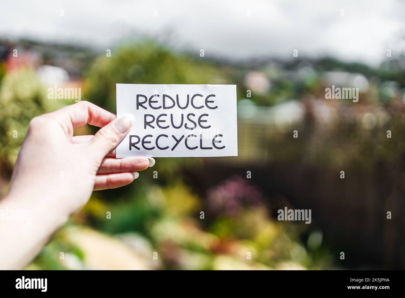reduce reuse recycle sign in front of backyard bokeh, concept of ...