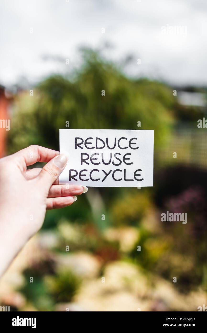 reduce reuse recycle sign in front of backyard bokeh, concept of ...