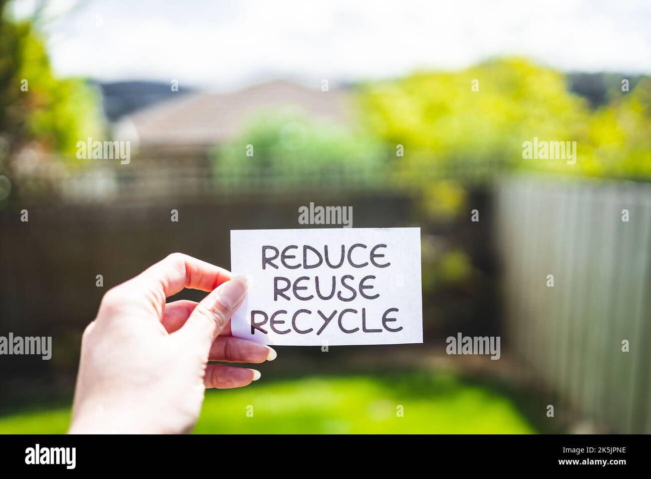reduce reuse recycle sign in front of backyard bokeh, concept of ...